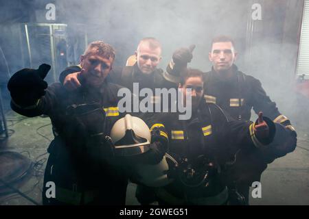 Group of professional firefighters wearing full equipment, oxygen masks ...