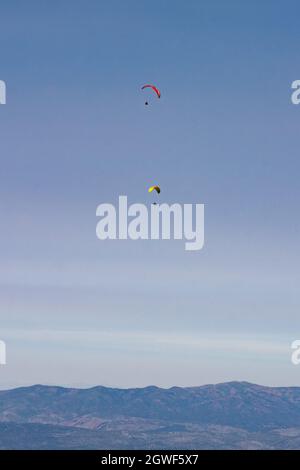 Two paragliders are flying in the valley. Paragliding from the mountain ...