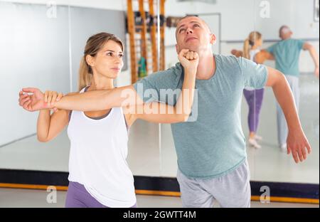 Ordinary female is fighting with trainer on the self-defense course for ...