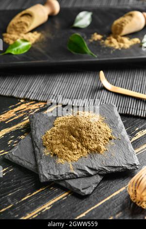 Pile of hojicha powder on black wooden background Stock Photo - Alamy