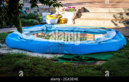 A deflated inflatable pool on the backyard lawn Stock Photo - Alamy