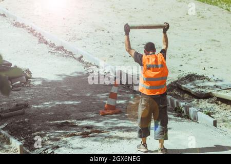 Construction worker hits his hard hat with a wrench Stock Photo - Alamy