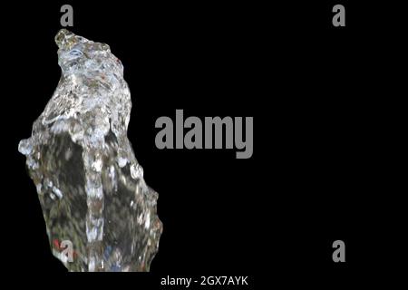 Small water jet on a black background Stock Photo - Alamy