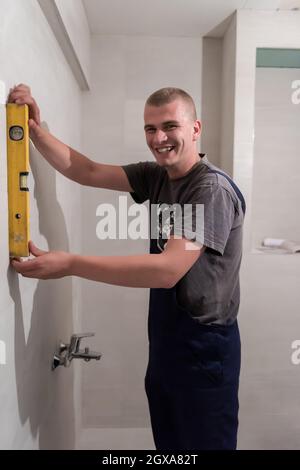 Professional plumber using bubble level for installing new heating ...