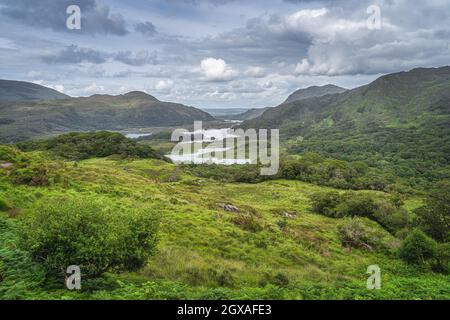 Patches of sunlight illuminating trees, meadows and mountains on Irish ...
