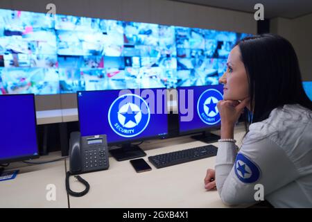 Female security operator working in a security data control room ...