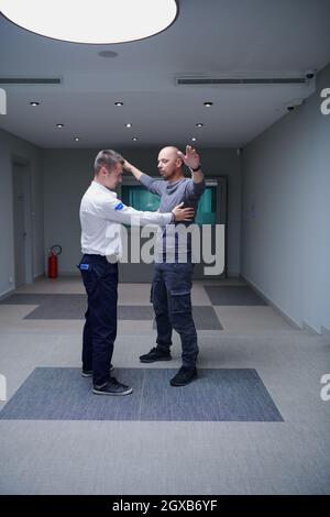 Security guard making body searching procedure with a metal detector on ...