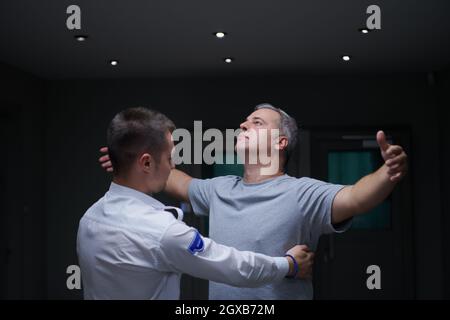 Security guard making body searching procedure with a metal detector on ...