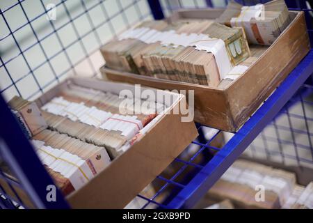 Carton boxes filled with sorted money and stored in a cage in the ...