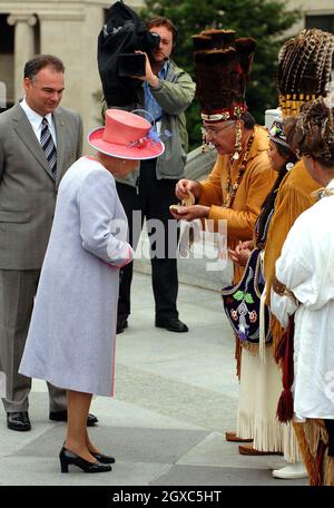 Queen Elizabeth II receives a gift during a visit to Gorgie City Farm ...