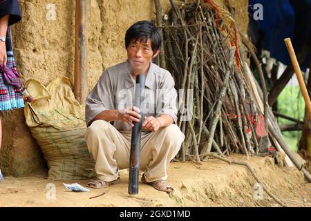 Vietnamese man smoking tobacco with traditional bamboo pipe, Old Quater ...