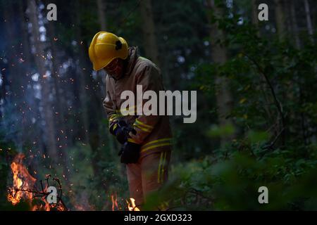firefighter hero in action danger jumping over fire flame to rescue and ...