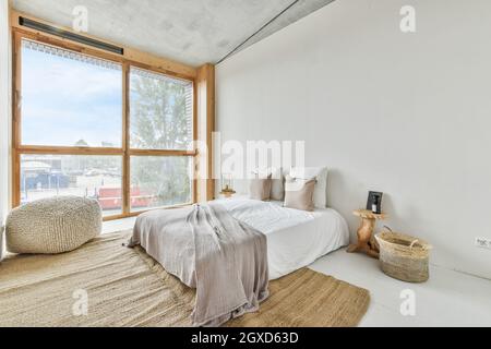 Creative design of bedroom with cushions and cover on bed between door ...