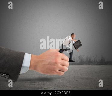 Businessman running away from a big hand Stock Photo - Alamy