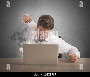Stressed businessman breaks the computer with punch Stock Photo - Alamy
