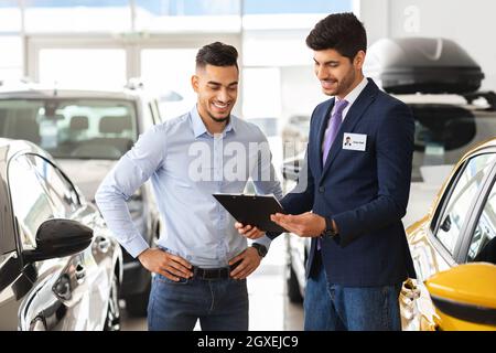 Attractive showroom manager showing customer car specifications Stock ...