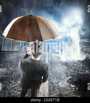 Businessman sheltering from the rain Stock Photo - Alamy