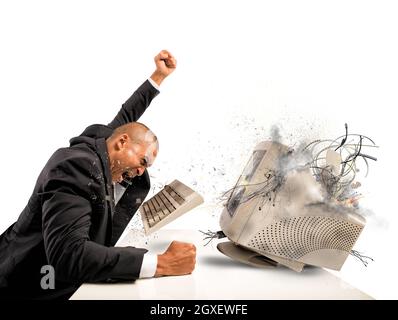 Businessman who breaks furiously an old computer Stock Photo - Alamy