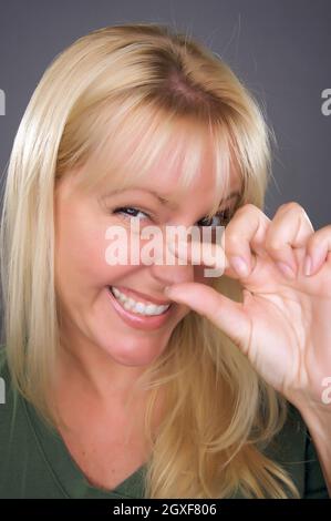 Female indicating little bit gesture against white background Stock ...