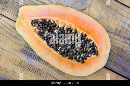 Papaya on the wooden board: cross section Stock Photo - Alamy