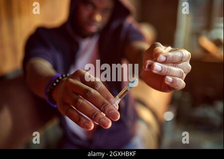 Male junkie holds syringe in hands. Drug addiction concept, addicted ...