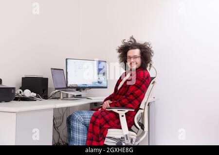 young graphic designer in bathrobe working at home office using ...