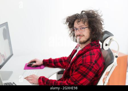 young graphic designer in bathrobe working at home office using ...