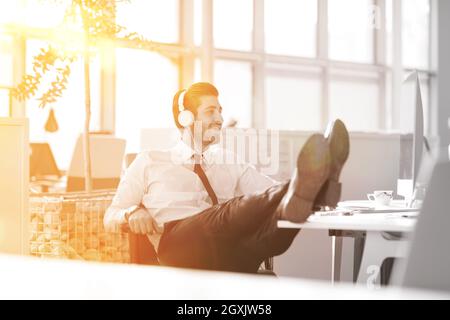Relaxed young businessman first at workplace at early morning ...