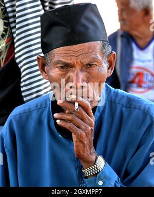 Man wearing fez hat, smoking narghile at Neveshir, Turkey. A hookah ...