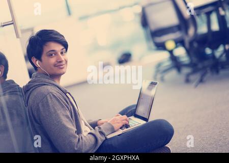 young indian software developer man using laptop computer writing programming code while sitting ...