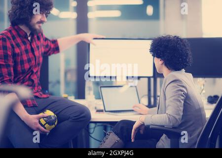 young software developers couple using laptop computer writing programming code while sitting on ...