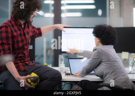 young software developers couple using laptop and desktop computer ...