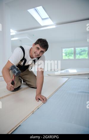 professional carpenter using rubber hammer while installing new ...