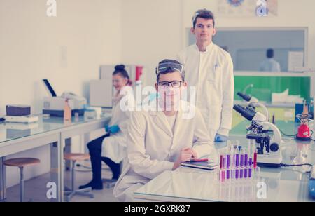 Group of young medical students doing research together in chemistry ...