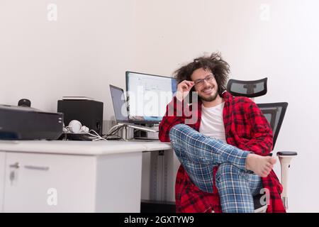 young graphic designer in bathrobe working at home office using ...