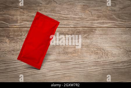 Blank Red Condiment Packet Floating on Aged Wood Background Stock Photo ...