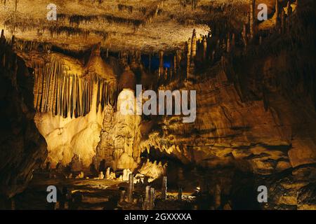 a cave with stalagmites and stalactites. The cave is large and dark ...