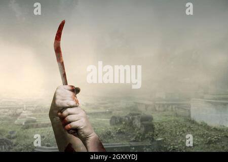 Zombie hands with wound holding sickle on the cemetery Stock Photo - Alamy