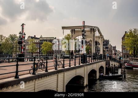 A traditional drawbridge crossing a canal in Amsterdam, blending ...