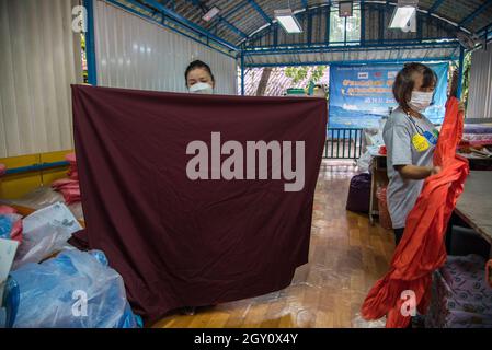A woman holds a material for sewing a personal protective equipment ...
