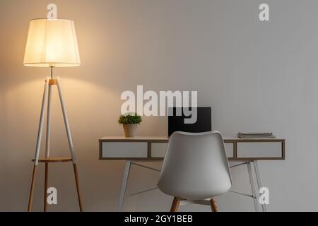 Modern laptop and glowing lamp on table in room Stock Photo - Alamy