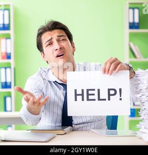 The businessman having problems with paperwork and workload Stock Photo ...
