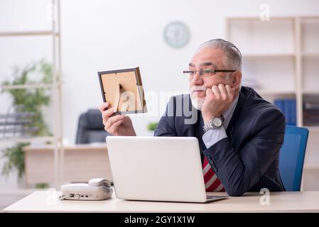 Old businessman employee missing wife at workplace Stock Photo - Alamy