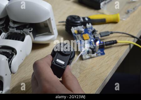 man repairing a robot. Close up of male hands fixing a broken little ...