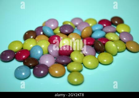 Multicolor chocolate candies on turquoise plate Stock Photo - Alamy