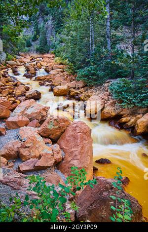 Small water fall cascading down rocks in the middle of a small mountain ...