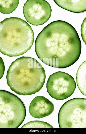 Thin slices of cucumber shot on a backlit white surface Stock Photo - Alamy