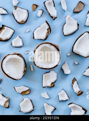 Broken coconut shells on a blue background Stock Photo - Alamy