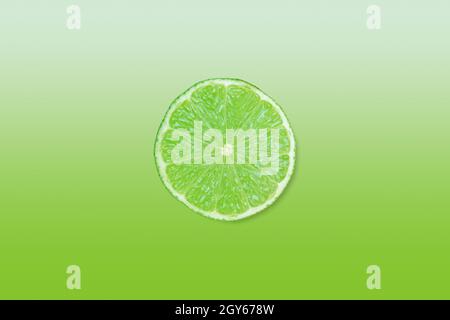 green lime slice over matching colour gradient background with copy ...