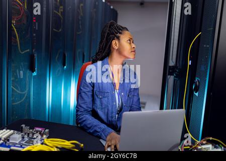 African american female computer technician making call and using ...